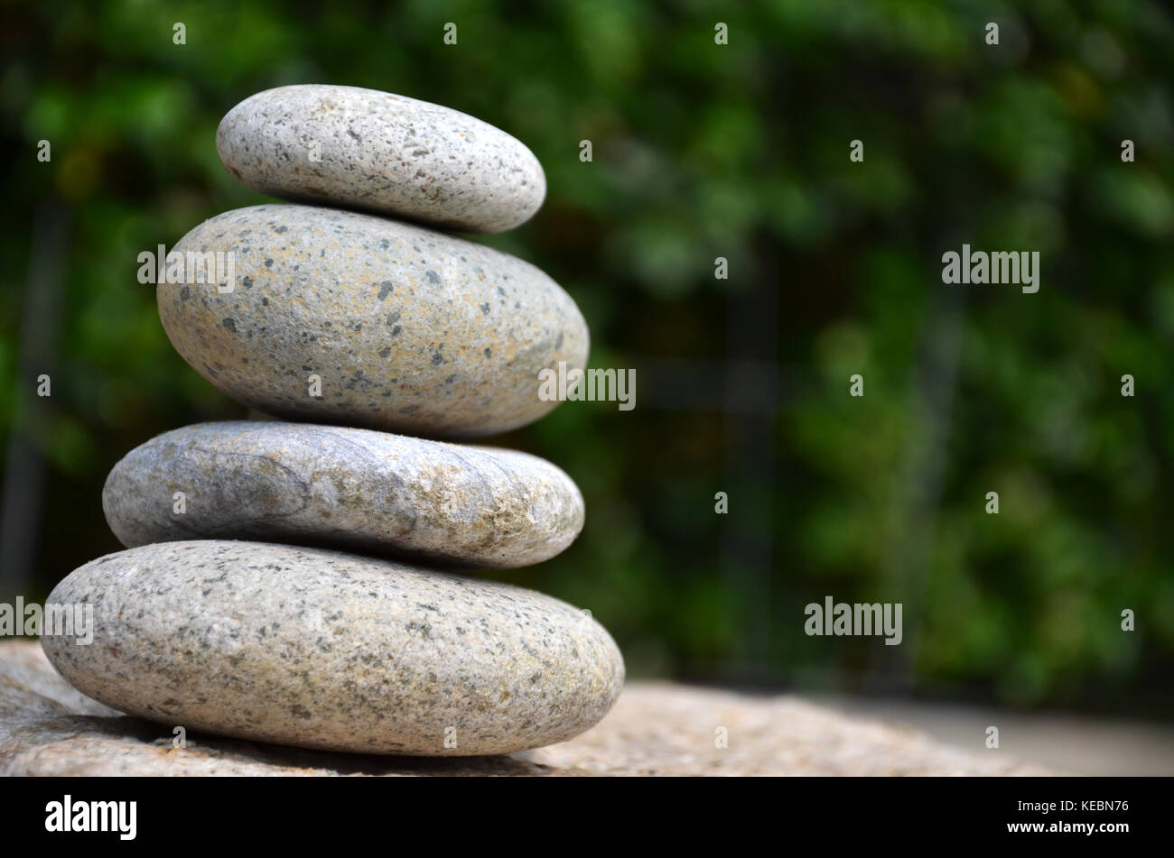 Stack of zen rocks in garden on green background Stock Photo - Alamy
