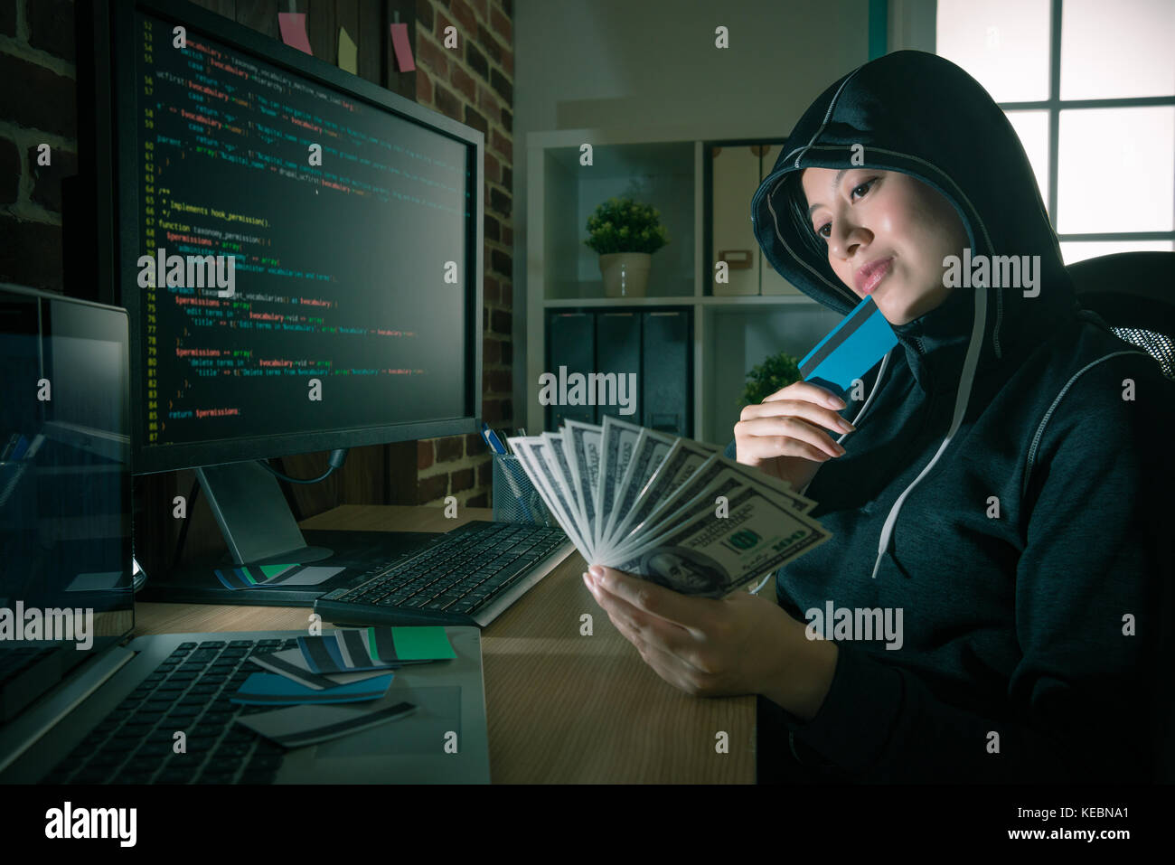 young smiling female hacker looking at banknote thinking how to use ...