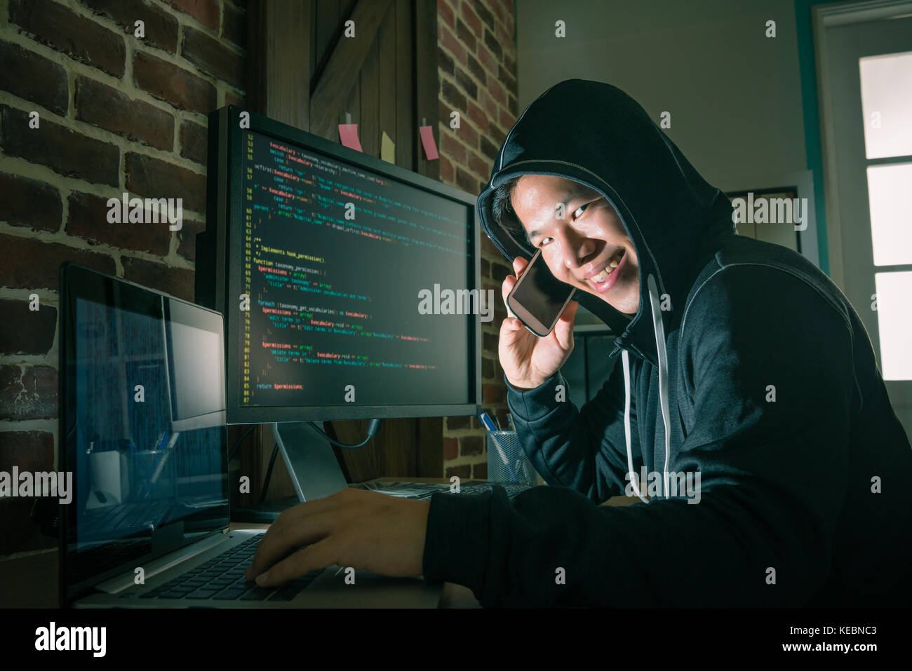 happy smiling hacker man using mobile smartphone doing ...