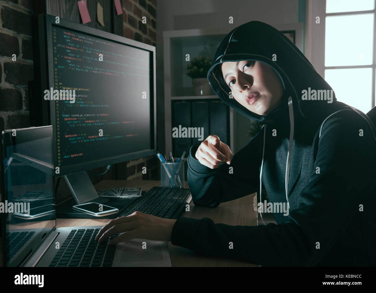 young female computer programmer as hacker doing illegal working online ...