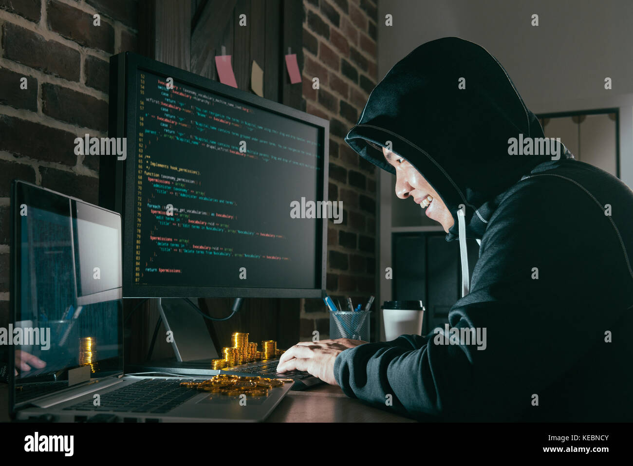 evil man hacker looking at computer online system and using keyboard ...