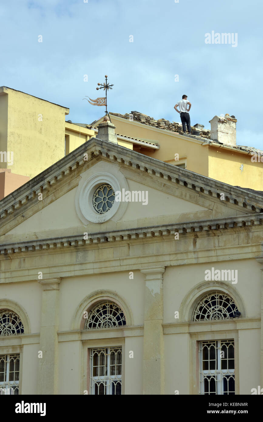 a man working on a roof in Kerkira, corfu, Greece breaching health and ...