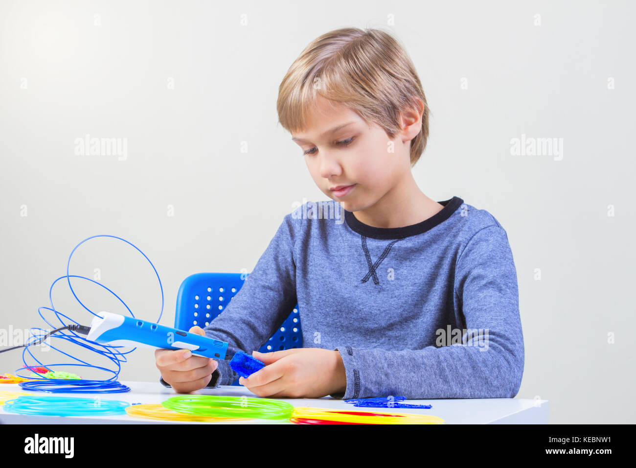 Boy creating with 3d printing pen Stock Photo - Alamy