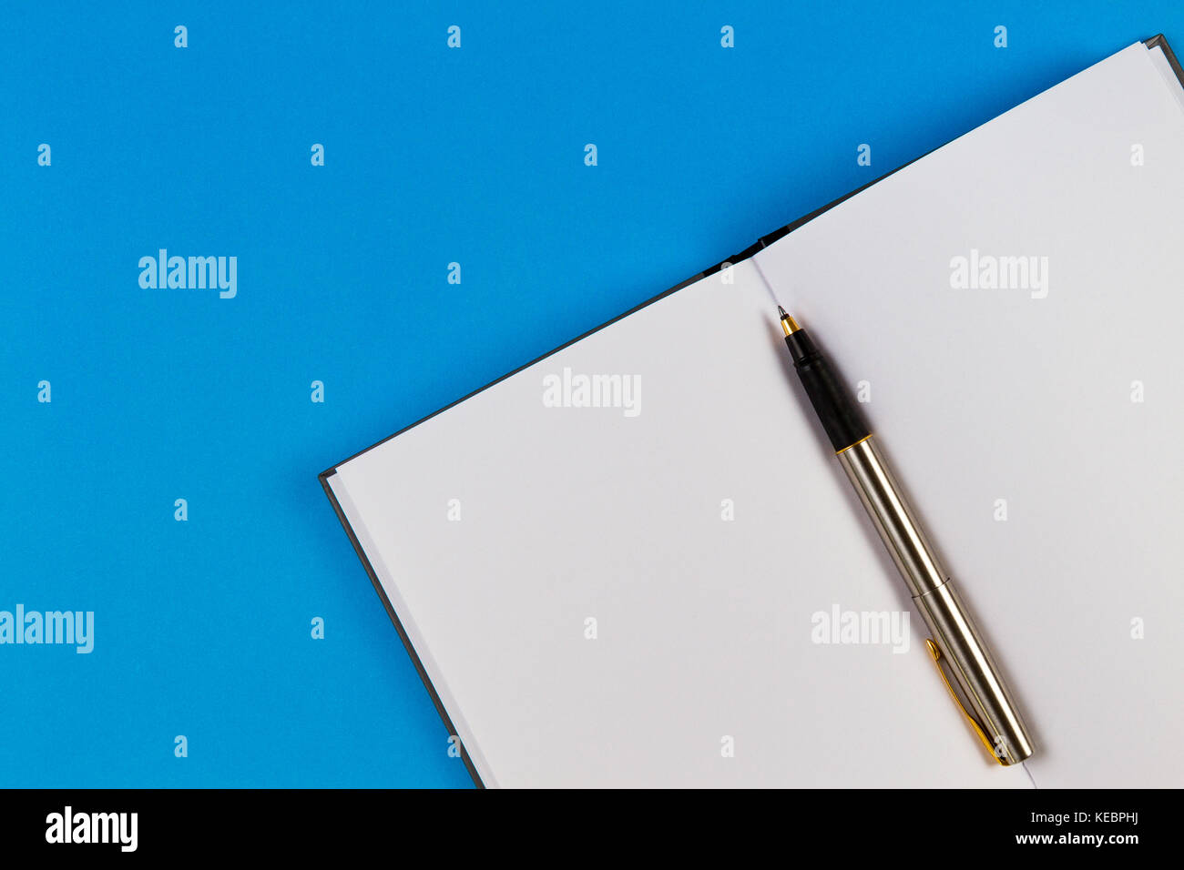 Open notebook with two blank pages and pen on blue background Stock ...
