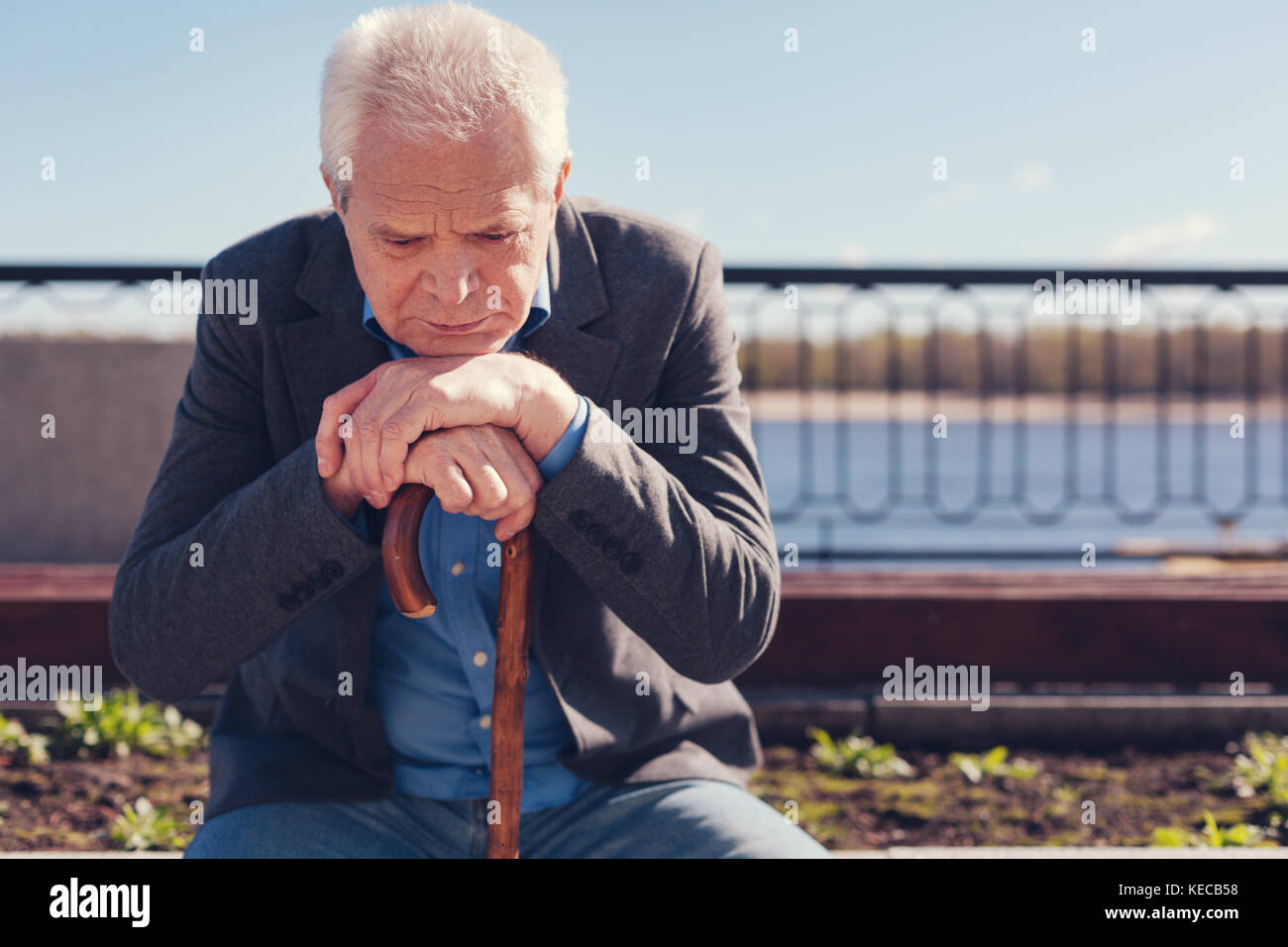 Upset senior man pondering while sitting on bench Stock Photo - Alamy