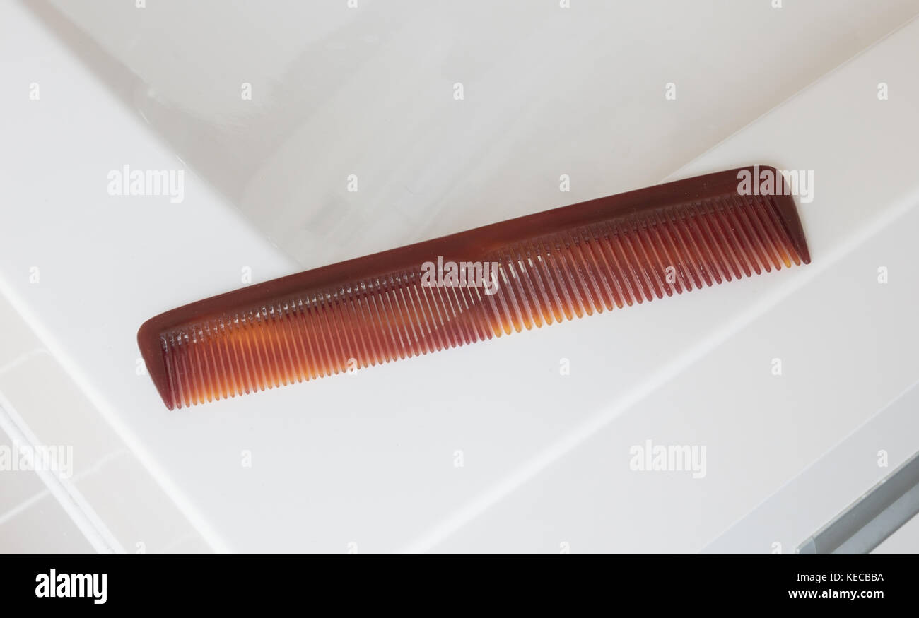 Used brown comb in a bathroom - Selective focus Stock Photo - Alamy