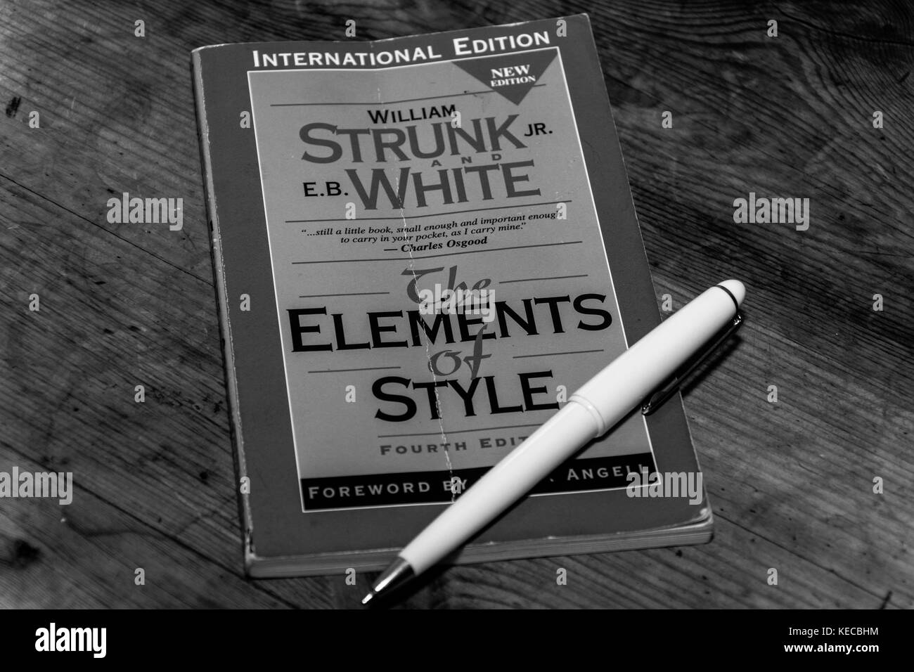 A white pen sitting on a worn copy of 'The Elements of Style' by ...