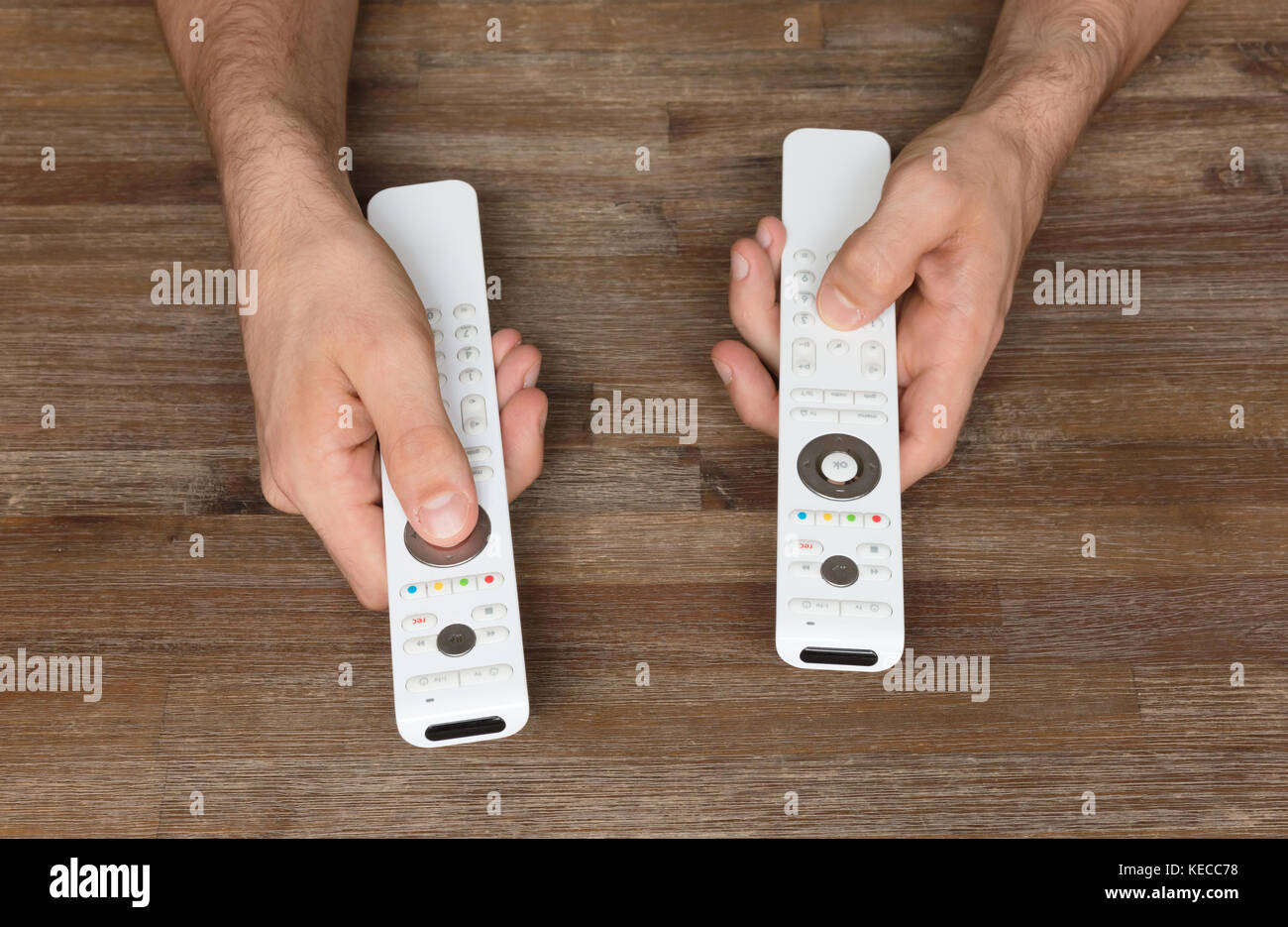 Man holding two white remotes in his hand - Take control! Stock Photo ...