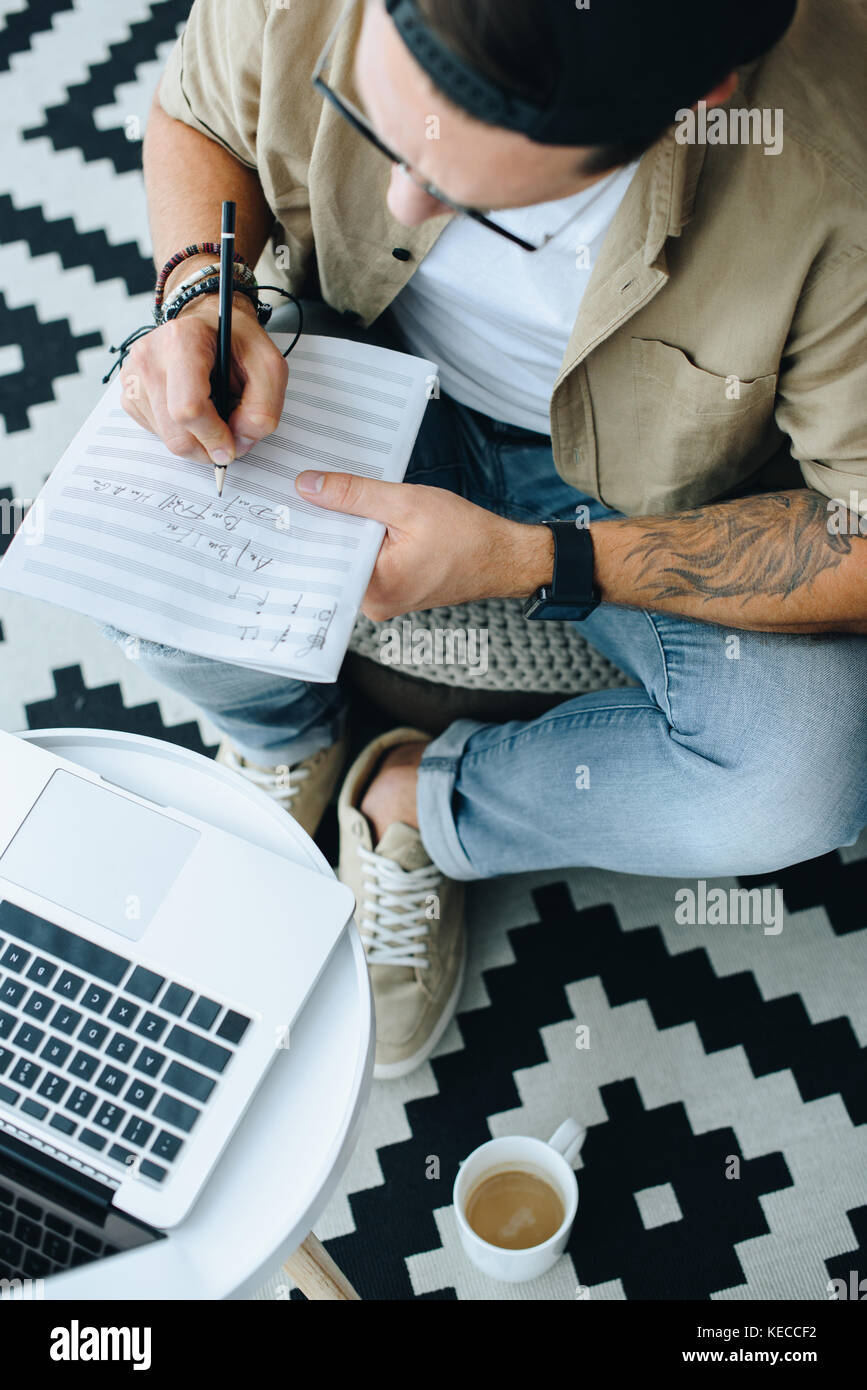 man writing notes and looking at laptop Stock Photo - Alamy