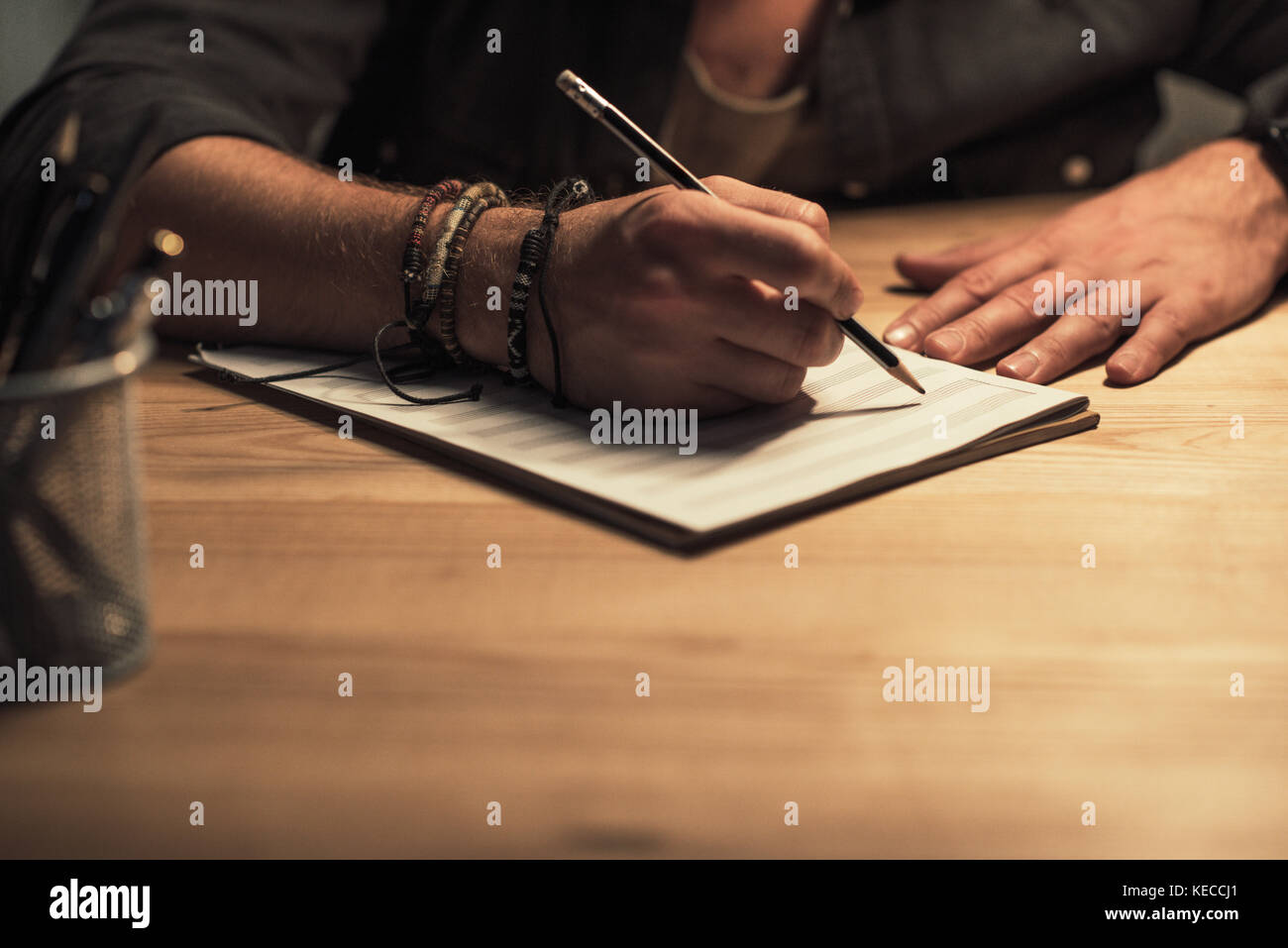 musician writing in music notebook Stock Photo - Alamy