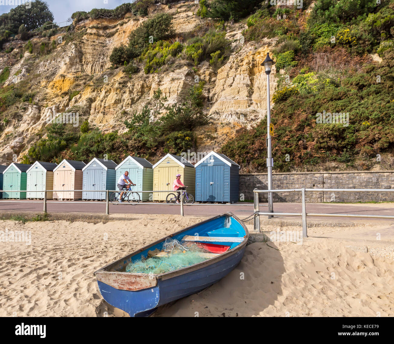 MULTI COLOURED BEACH HUTS ON THE BOURNEMOUTH SEAFRONT WITH A ROWING ...