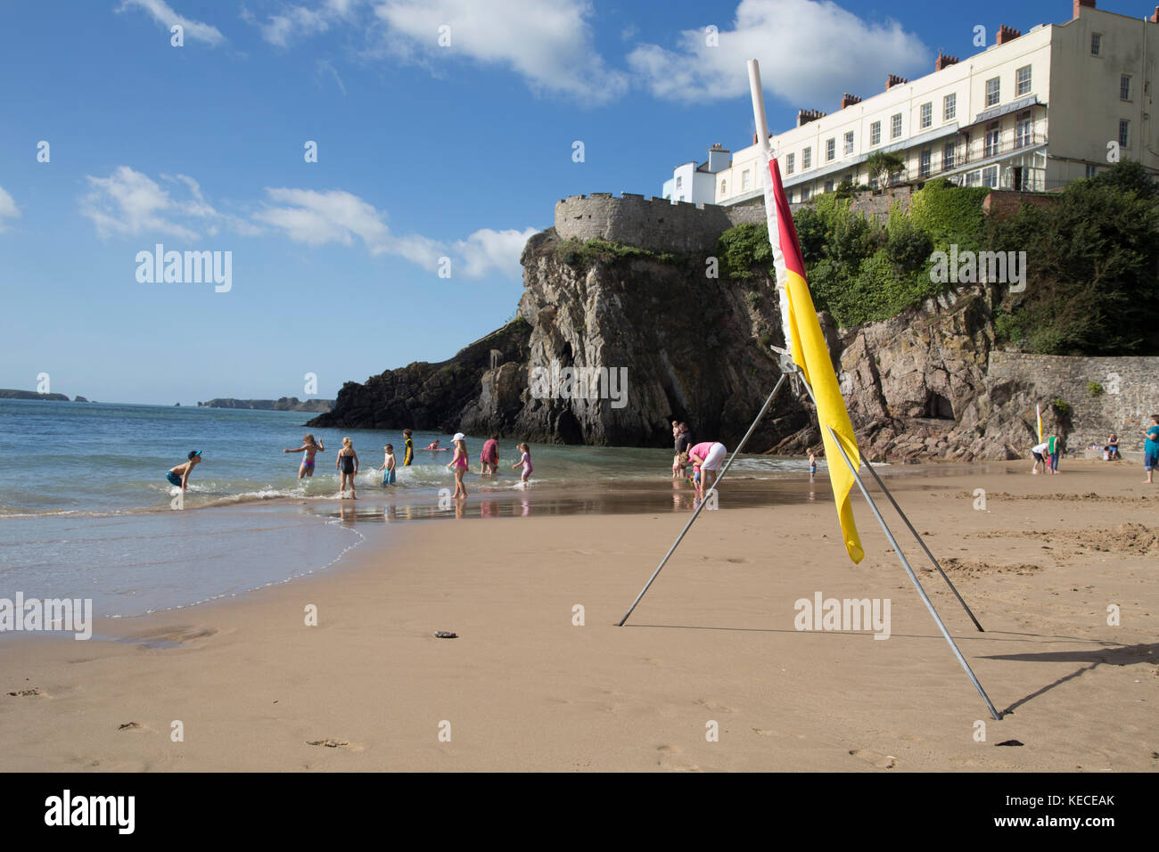 Flag and paddling families on Tenby beach, Pembrokeshire, Wales Stock ...