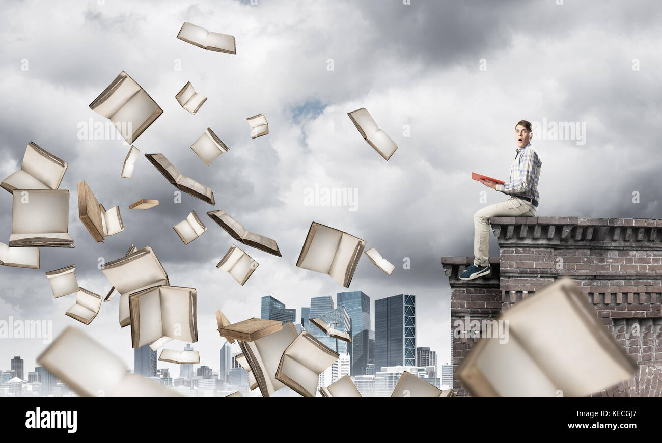 Man reading book and many of them flying in air Stock Photo - Alamy