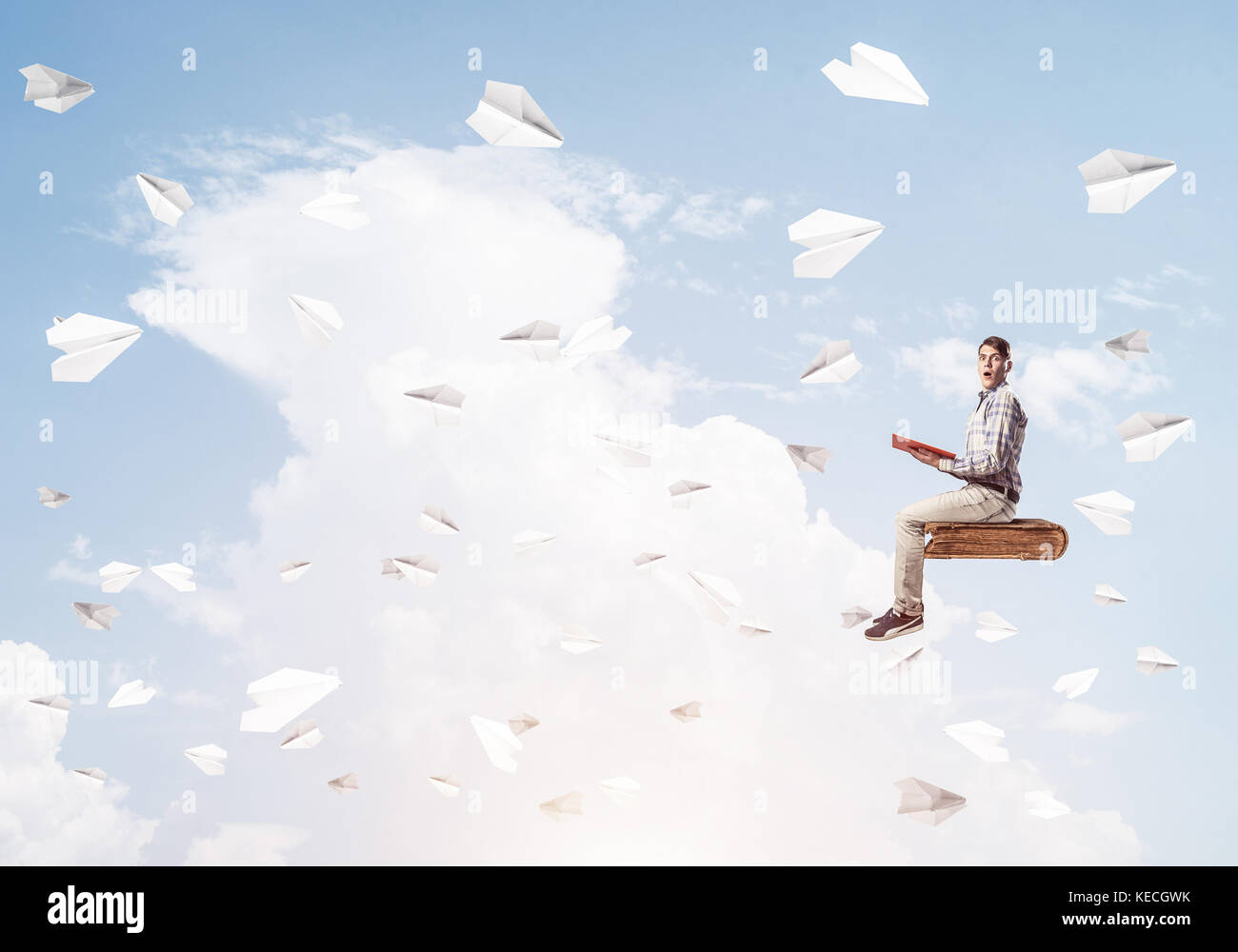 Handsome man student reading book and paper planes flying around Stock ...