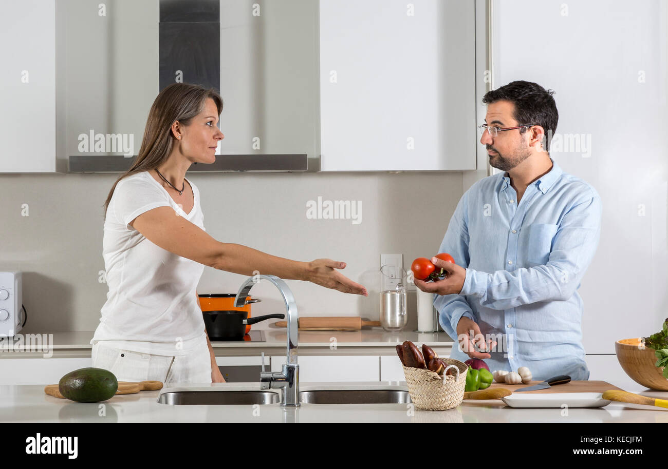 couple arguing while preparing food in a kitchen Stock Photo - Alamy