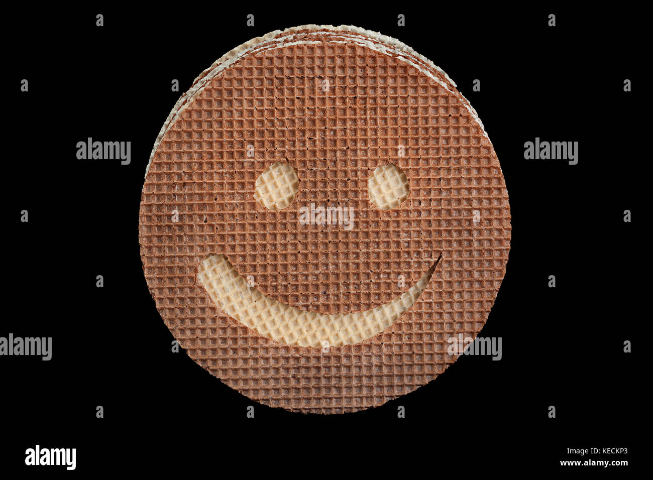Round wafer carvrd smile isolated on black background Stock Photo - Alamy