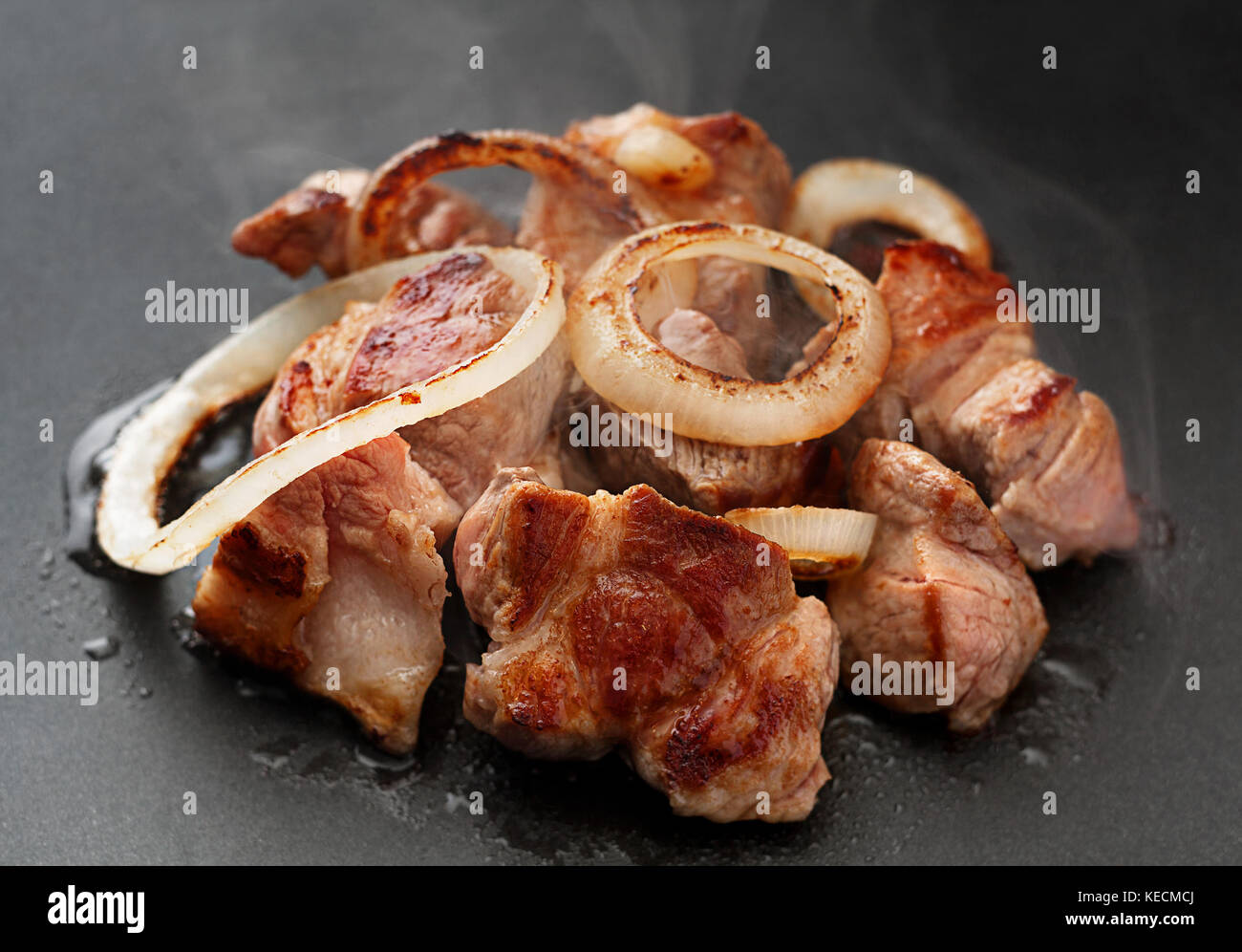 Grilled meat with orion rings on grill table Stock Photo - Alamy