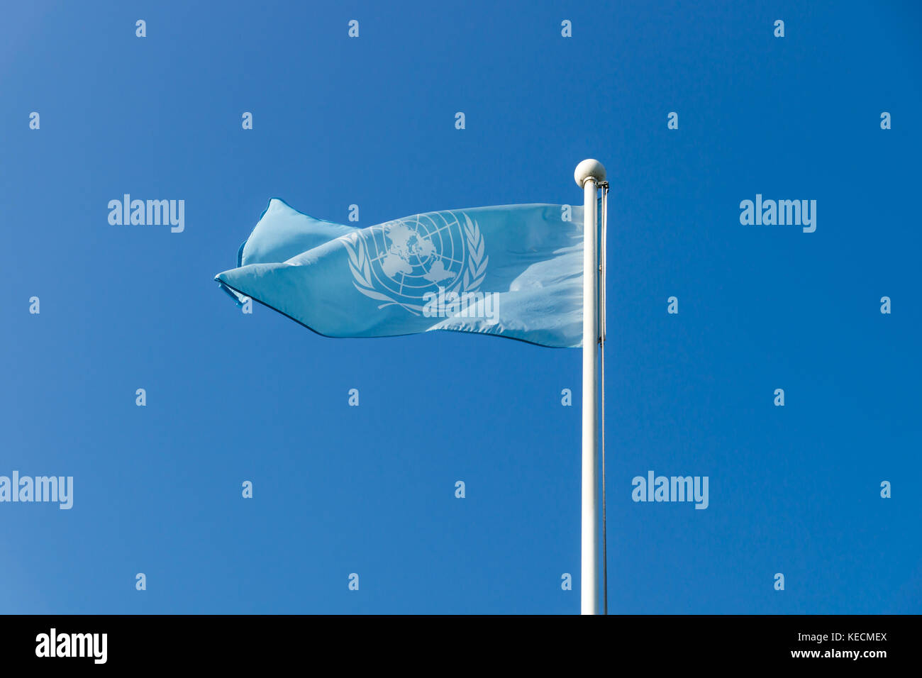 United Nations UN flag waving on cloudless blue sky at United Nations ...