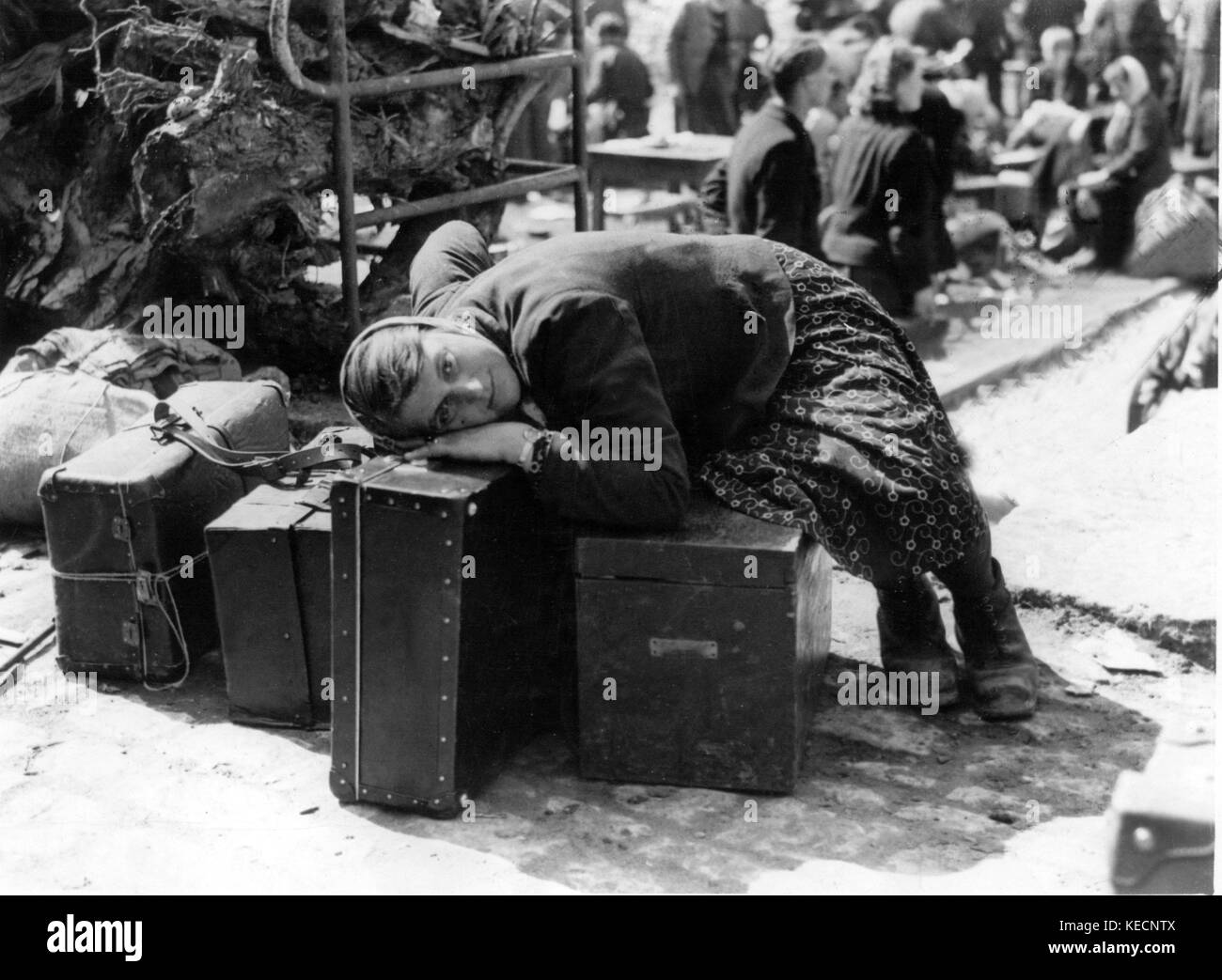 An exhausted Russian forced laborer takes a rest on luggage in April ...