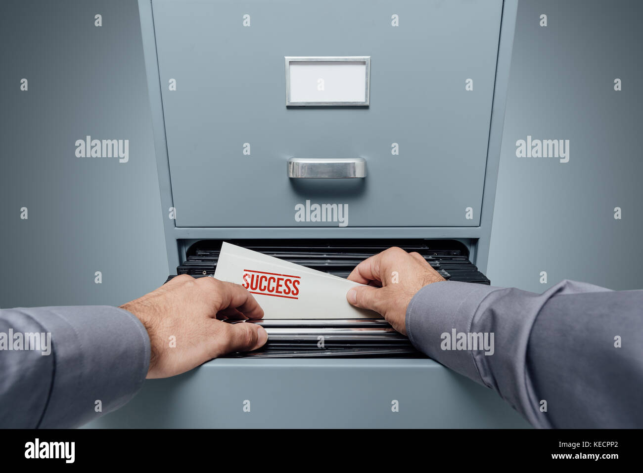 Office clerk searching for files in the filing cabinet, he finds a ...