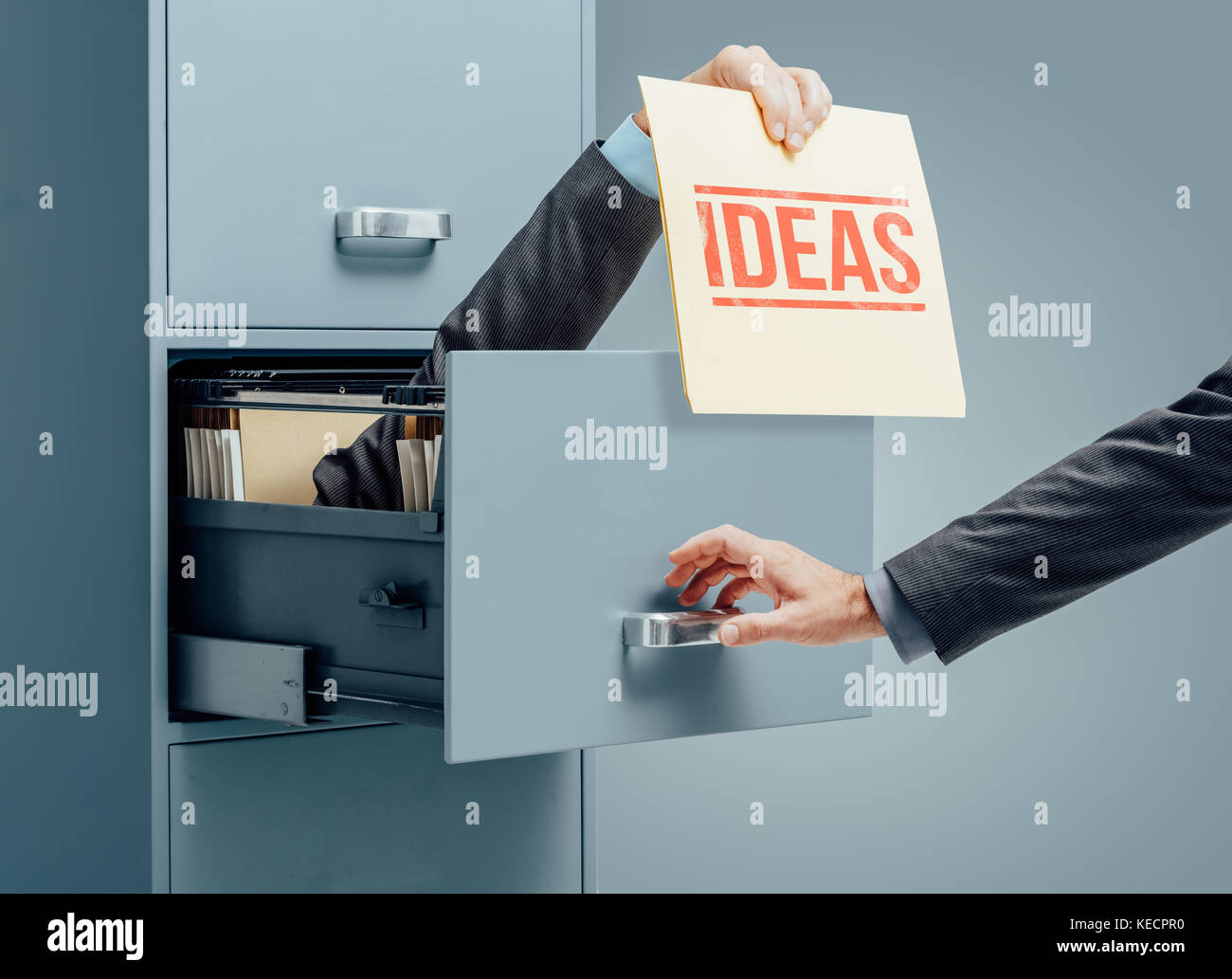Businessman inside a filing cabinet giving a file with innovative ideas ...