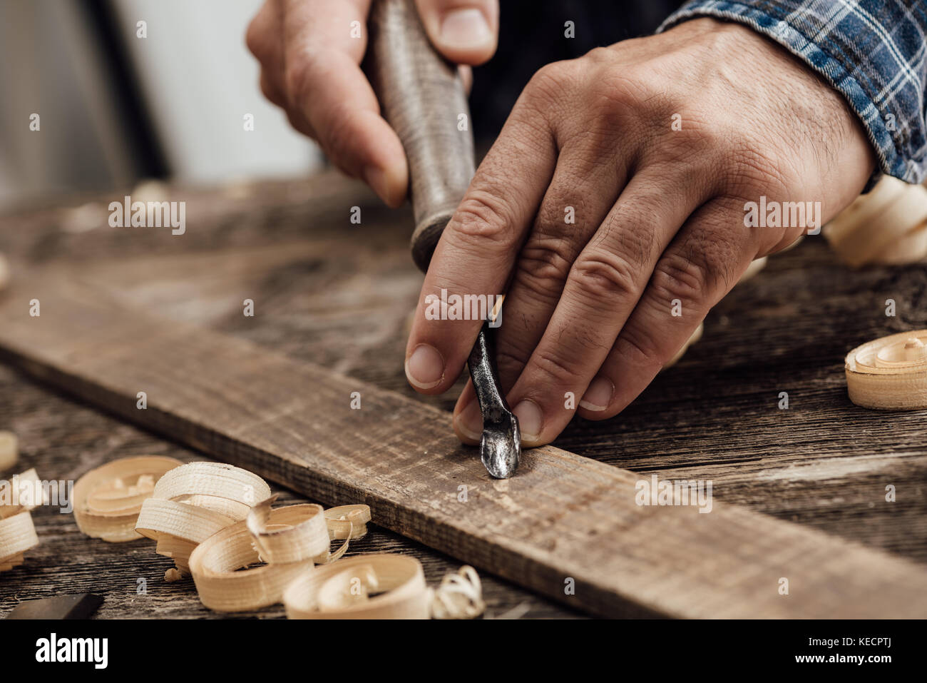 Professional carpenter at work, he is carving wood using a woodworking ...