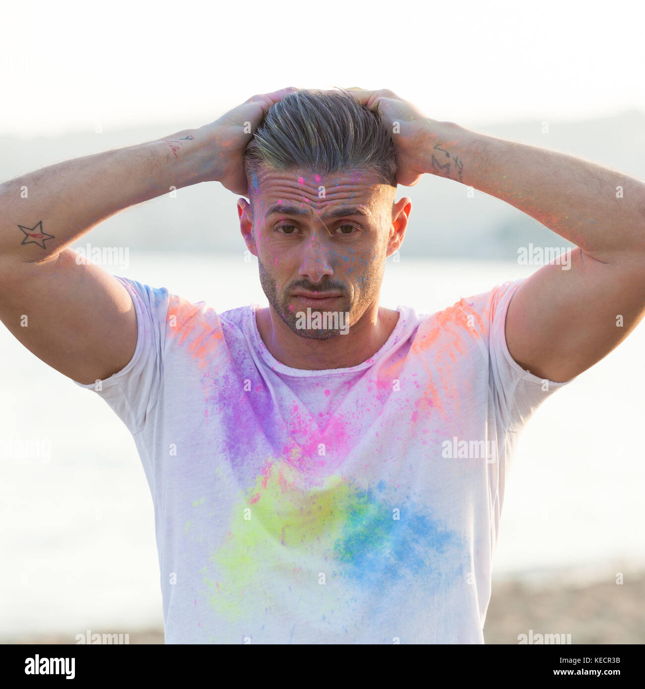Portrait of a beautiful young man at sunset with colored powder Stock ...