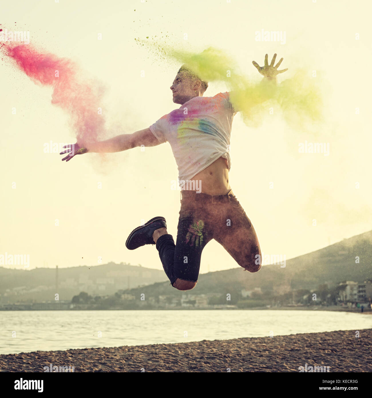 Portrait at sunset of a beautiful young man jumping with energy and ...