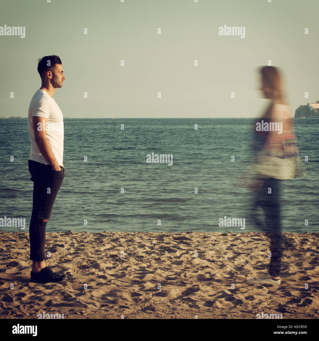 Beautiful young man at the beach imagining a woman Stock Photo - Alamy