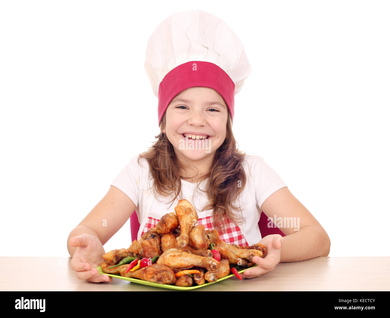 happy little girl cook with roasted chicken drumsticks on plate Stock ...
