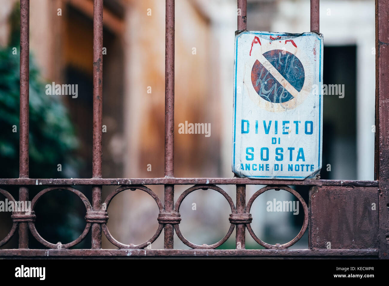 A "divieto di sosta" (no parking) sign attached to an old gate in Rome ...