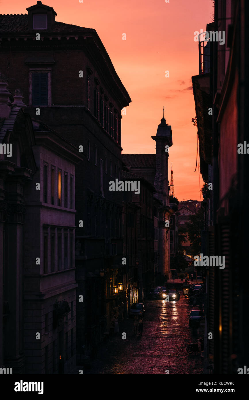 A vibrant sunset and an illuminated window in Via Giulia, Rome, Italy ...