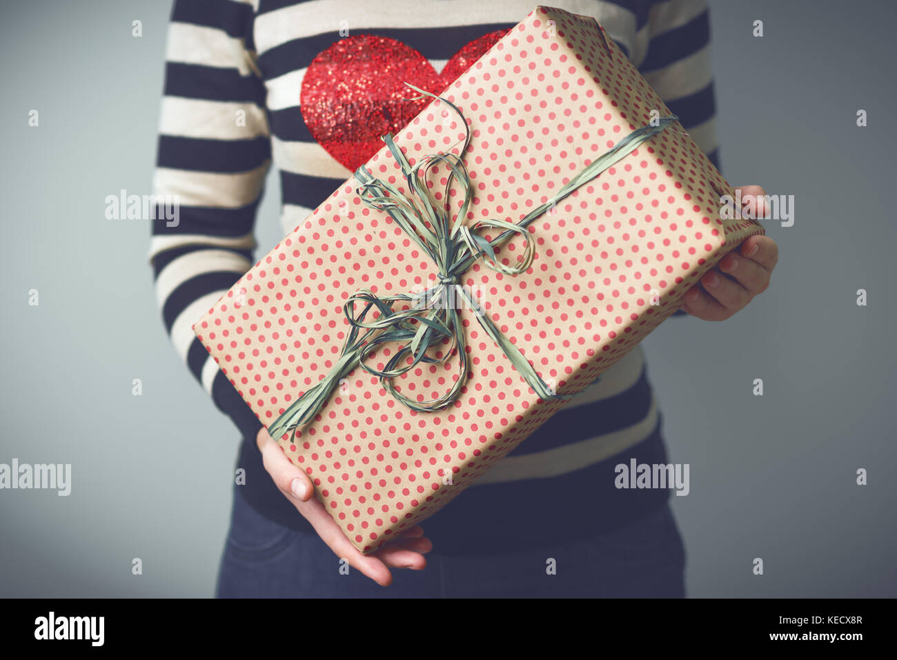 Girl holding a box with a Christmas present Stock Photo - Alamy