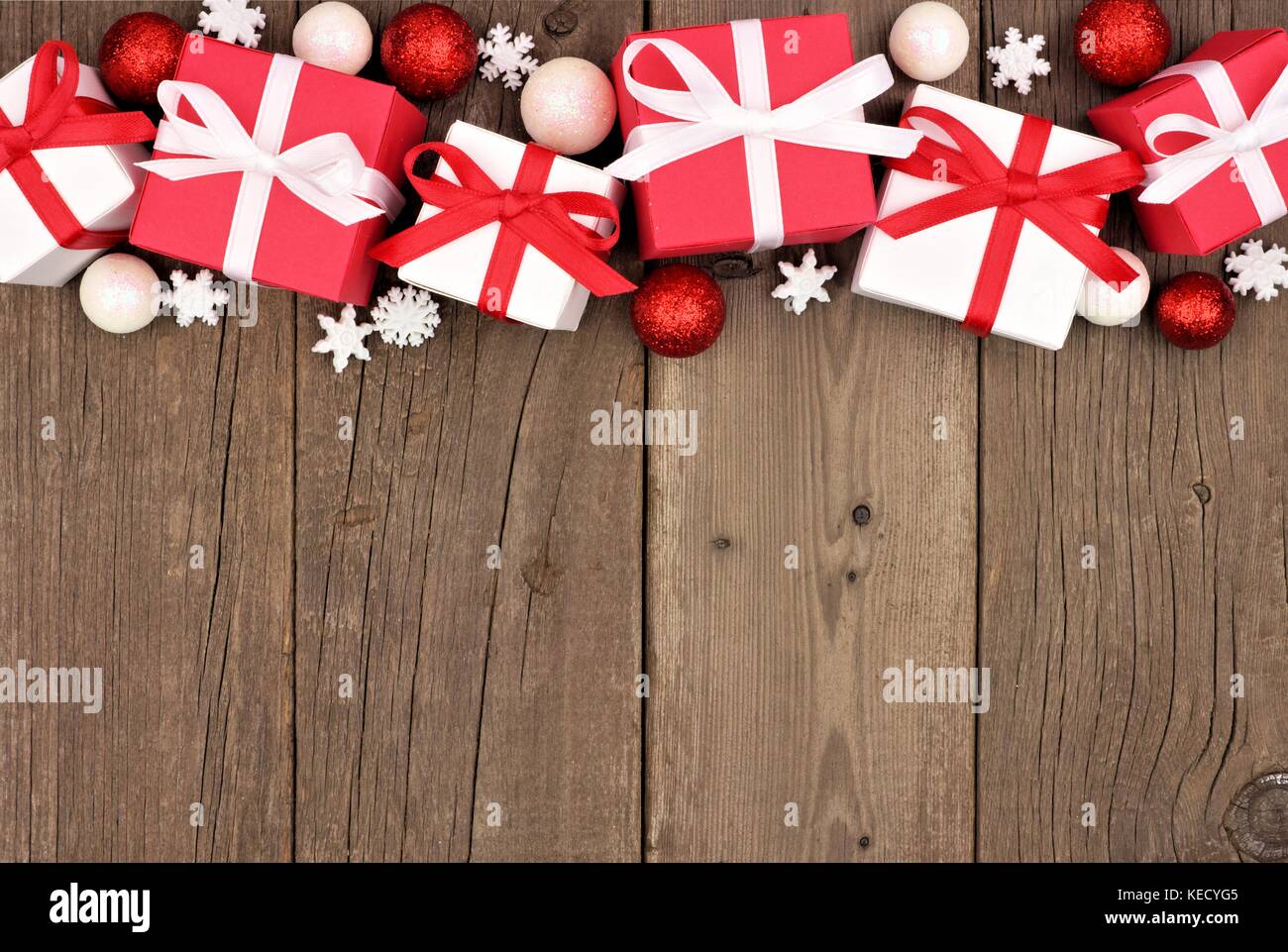 Red and white Christmas gift box top border over a rustic wood ...
