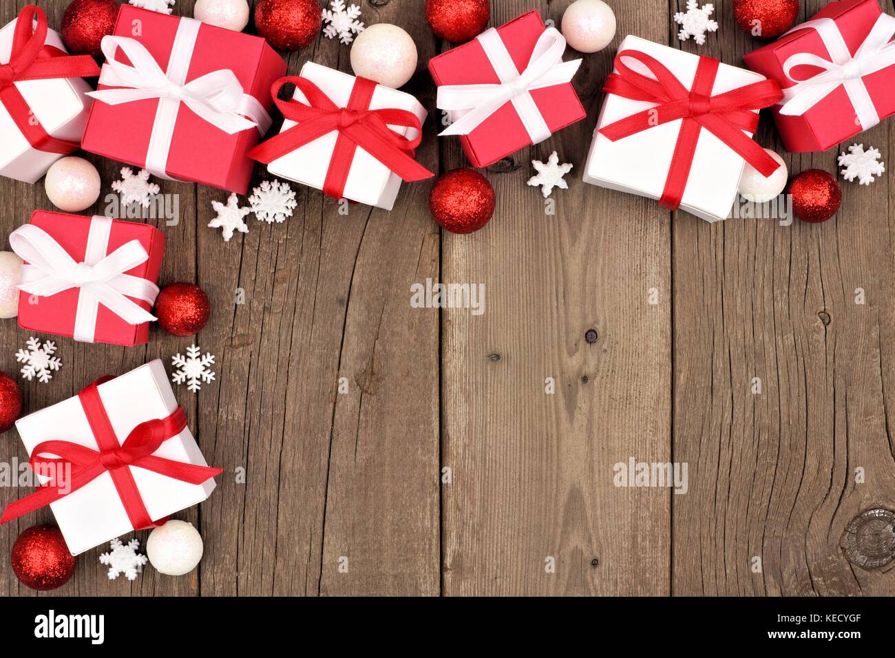 Red and white Christmas gift box corner border over a rustic wood ...