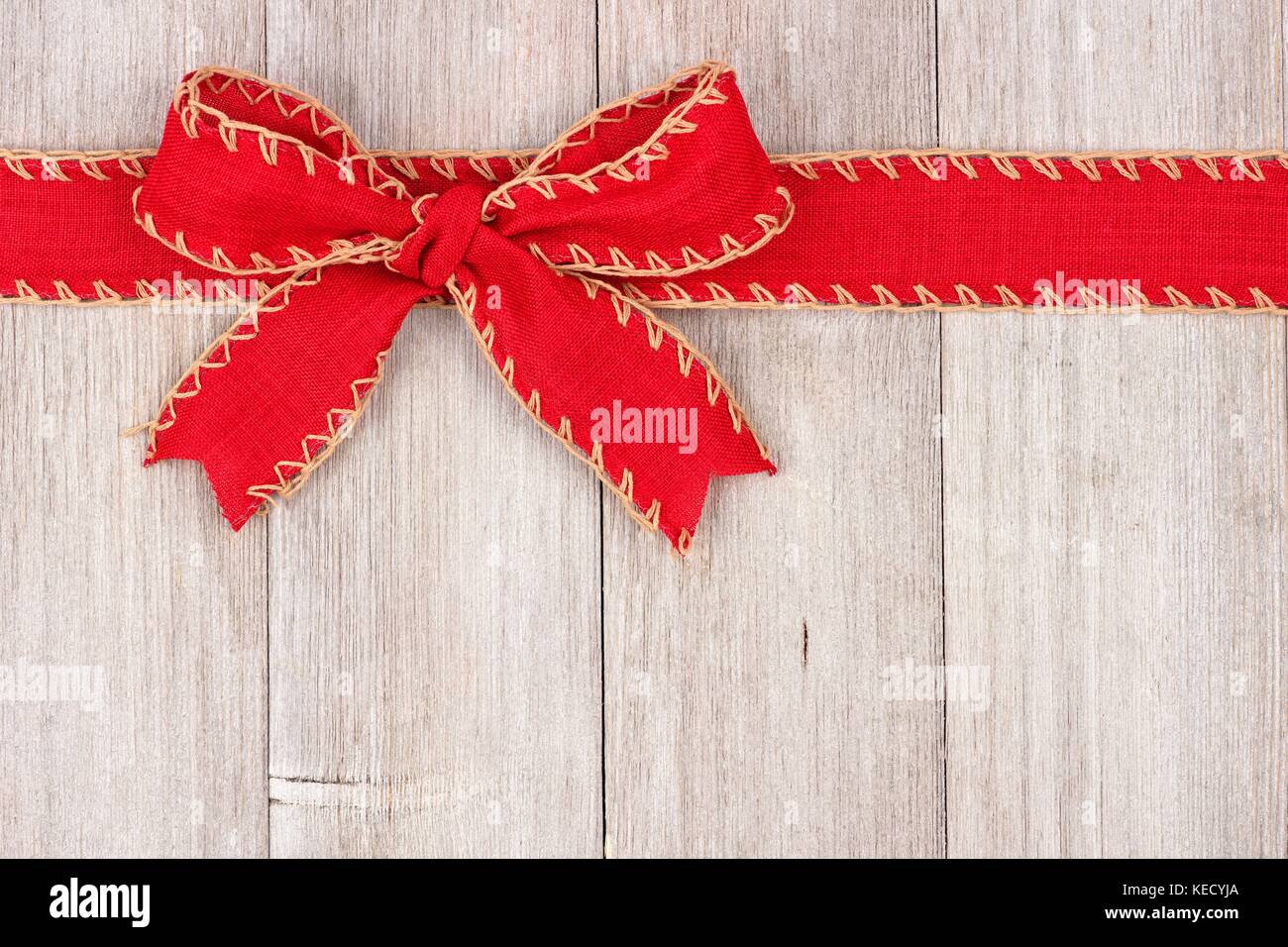 Rustic red Christmas bow and ribbon top border, above view on an old ...