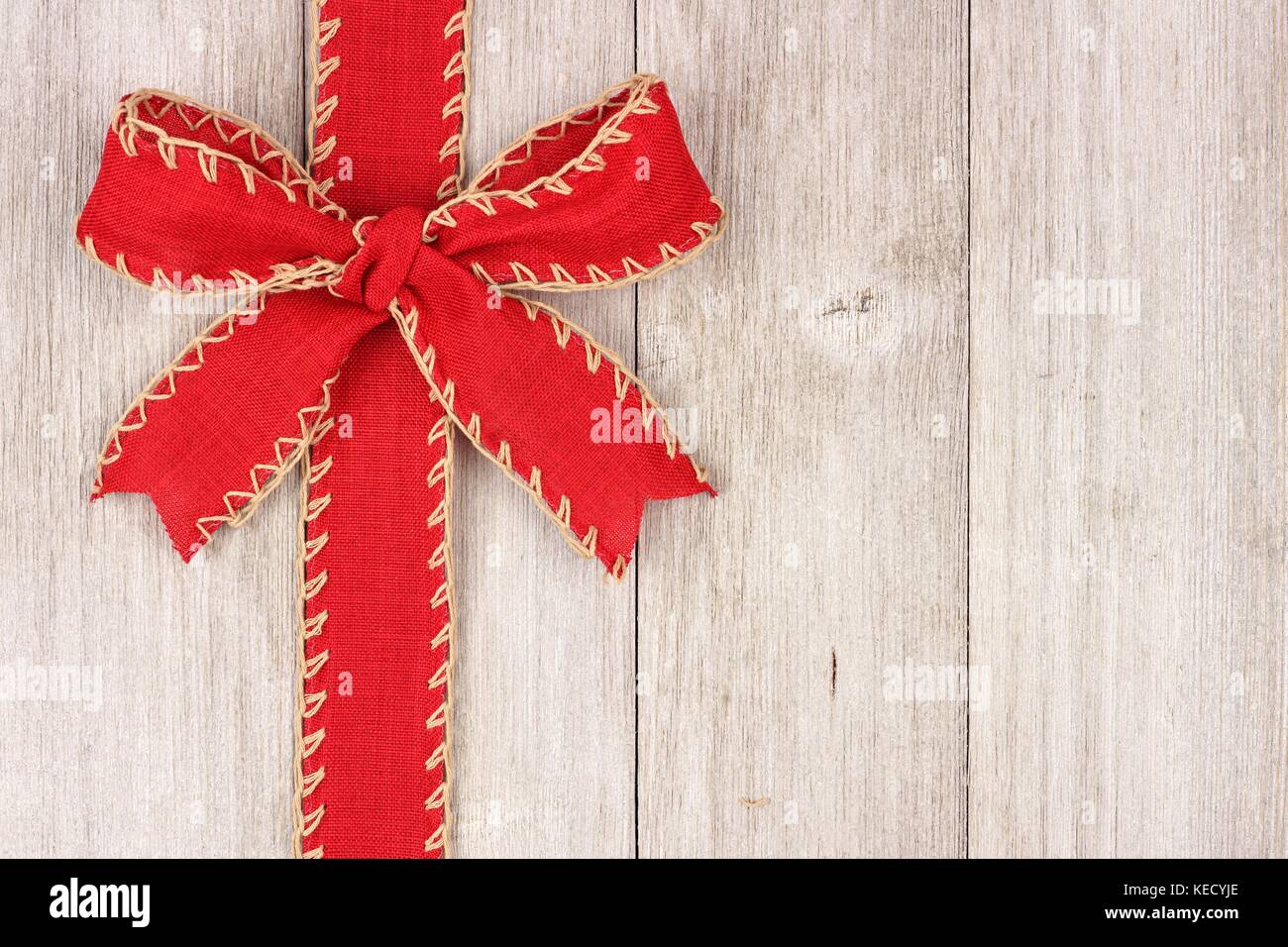 Rustic red Christmas bow and ribbon side border, above view on an old ...