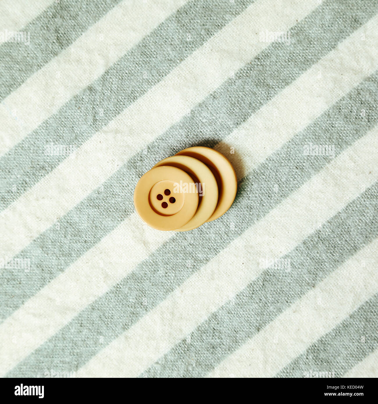 Beige simple button on stripe pattern cloth background Stock Photo - Alamy