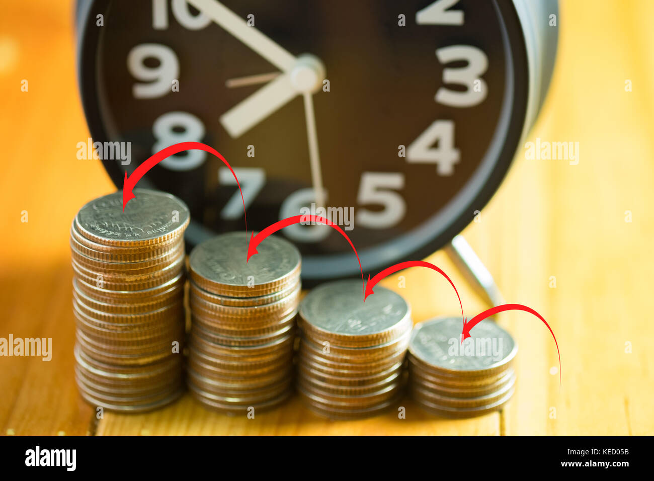 Alarm clock and step of coins stacks on working table with arrow up ...