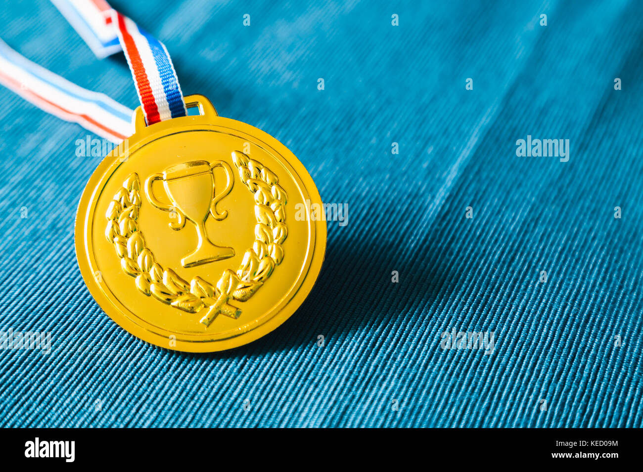 Gold medal on blue background Stock Photo - Alamy