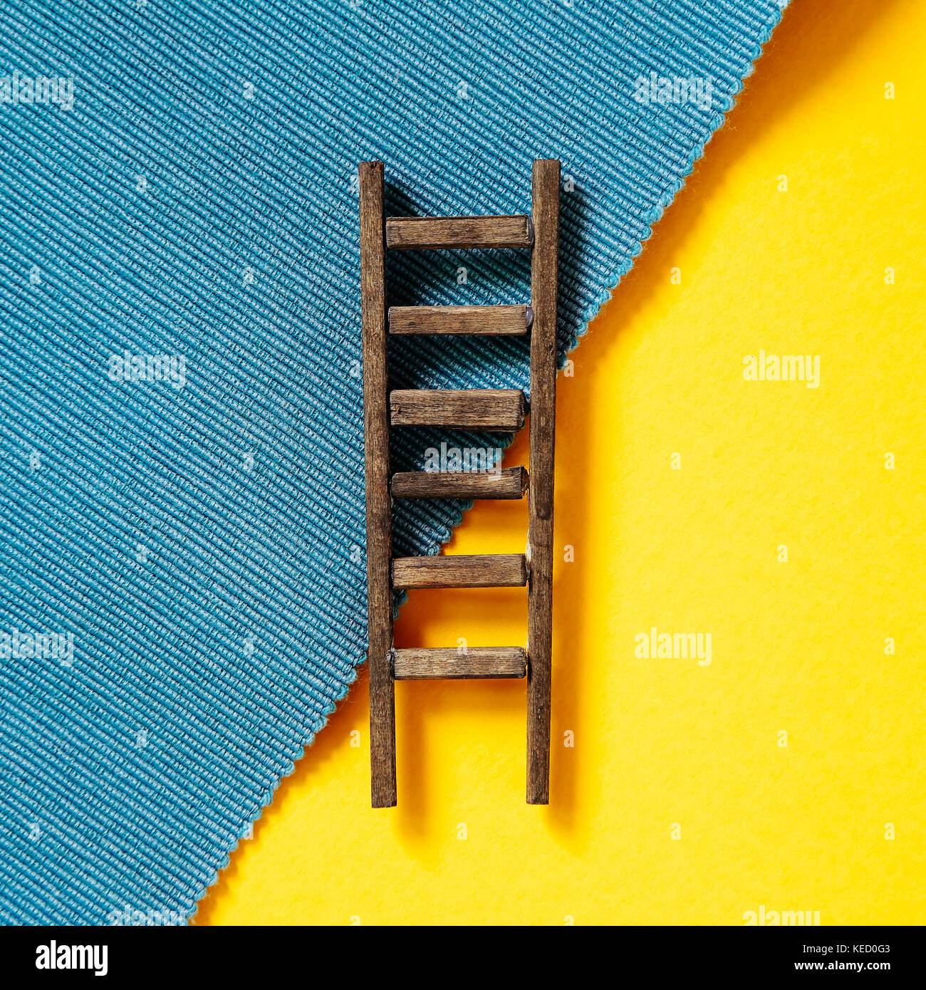 Wooden ladder on yellow and blue background Stock Photo - Alamy