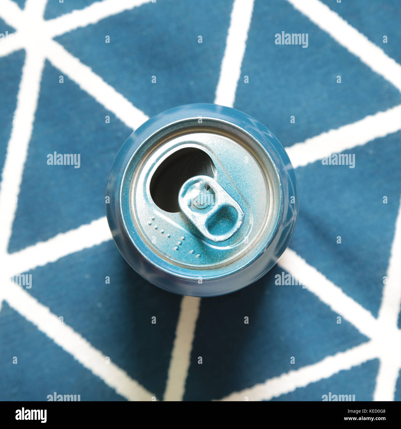 Empty can on blue fabric background Stock Photo - Alamy