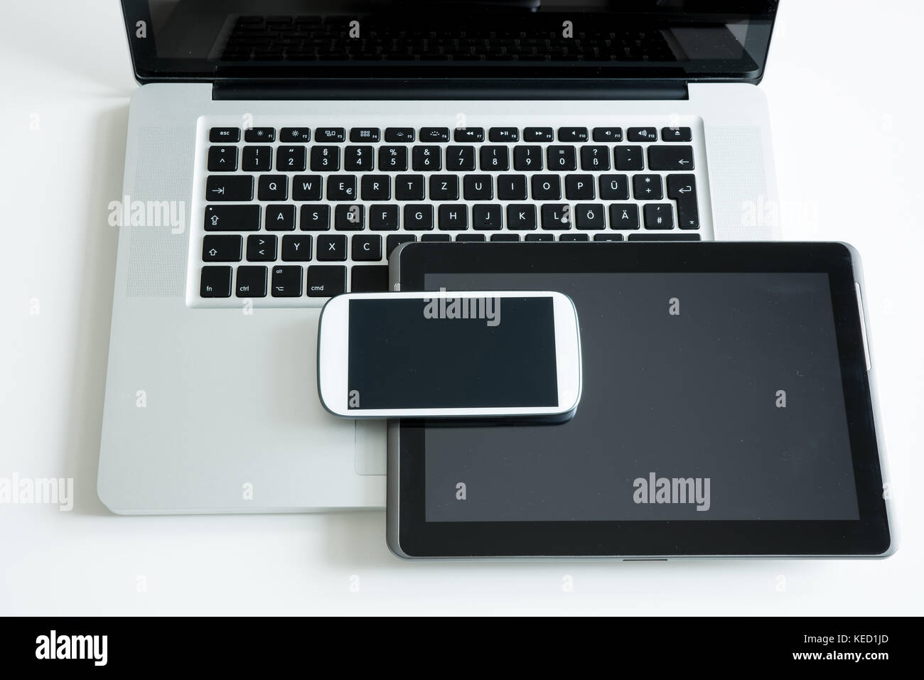 A smartphone, a laptop computer and a Tablet PC together on a desktop ...