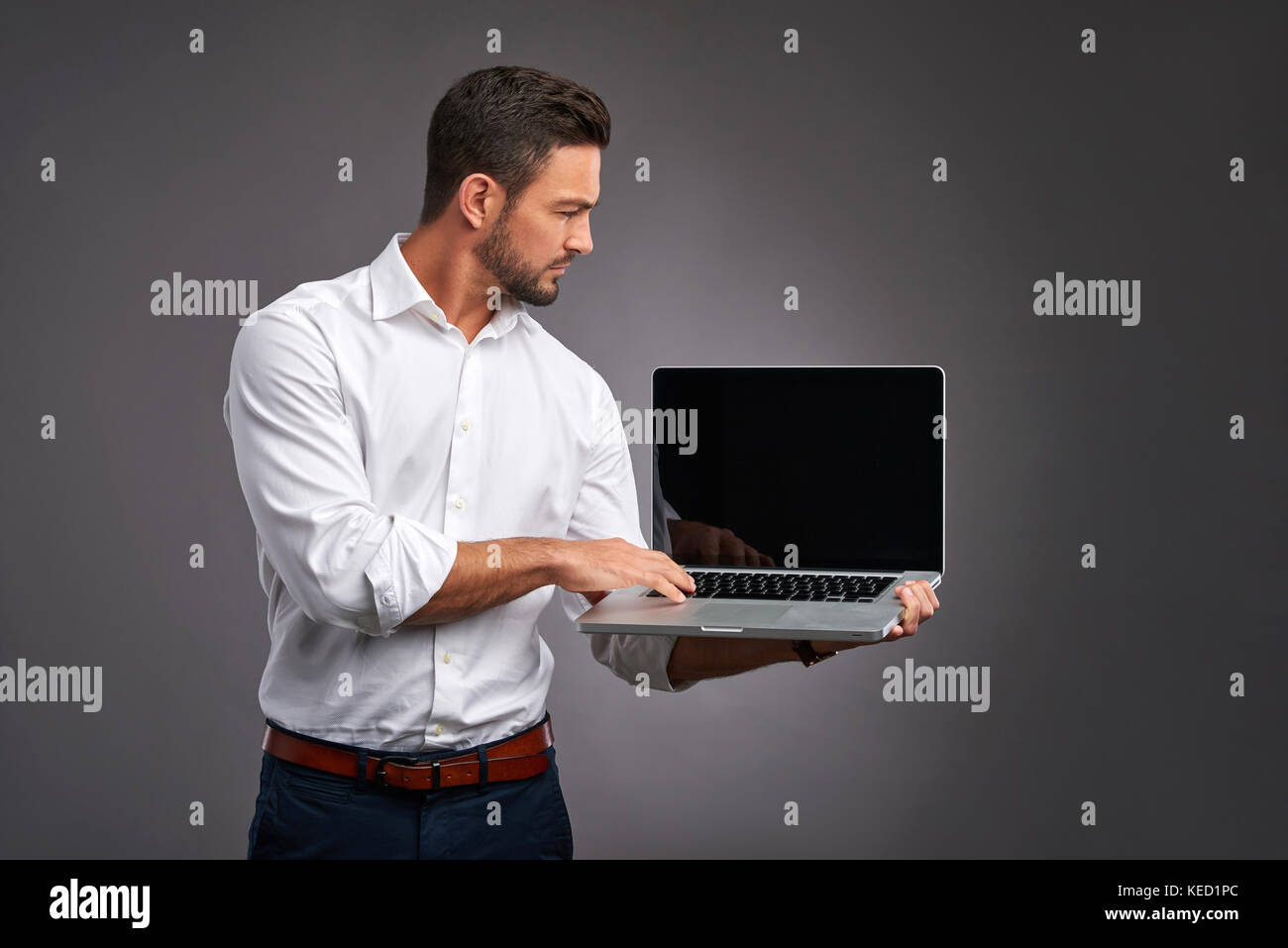 A handsome young man holding and showing the screen of a laptop Stock ...