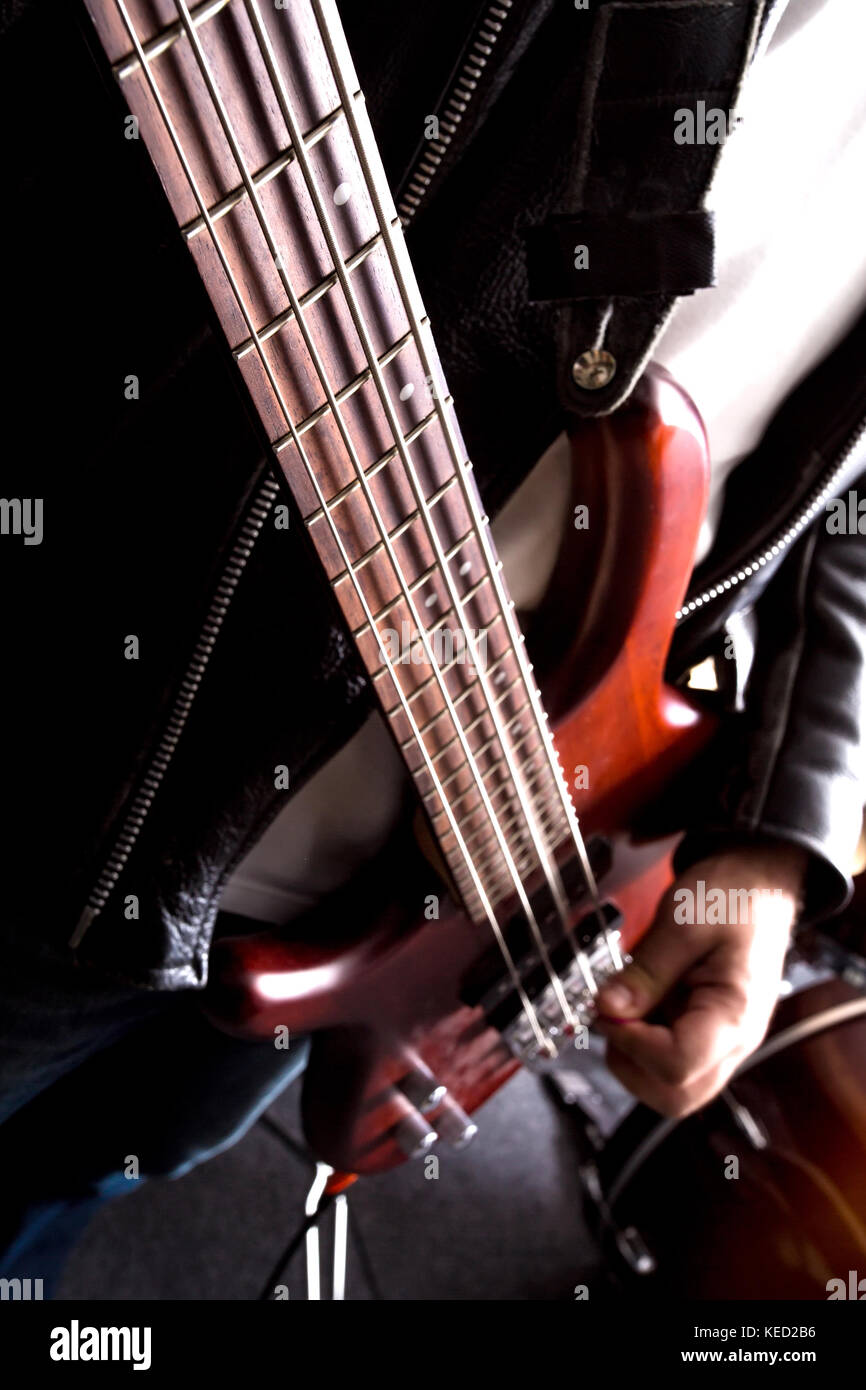A Rock musician playing passionately bass in the rehearsal Studio Stock ...