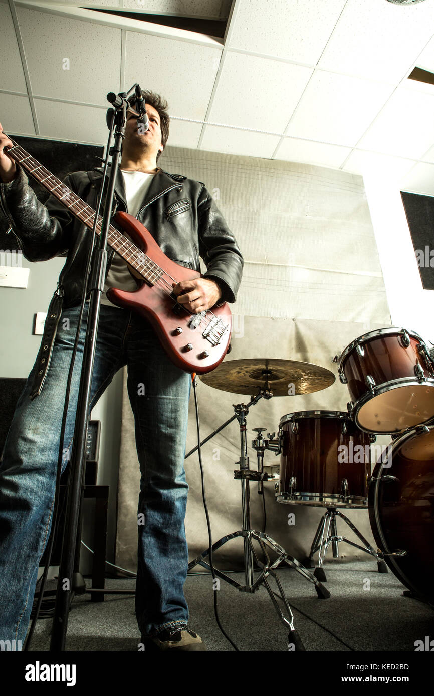 A Rock singer playing bass in the rehearsal Studio Stock Photo - Alamy