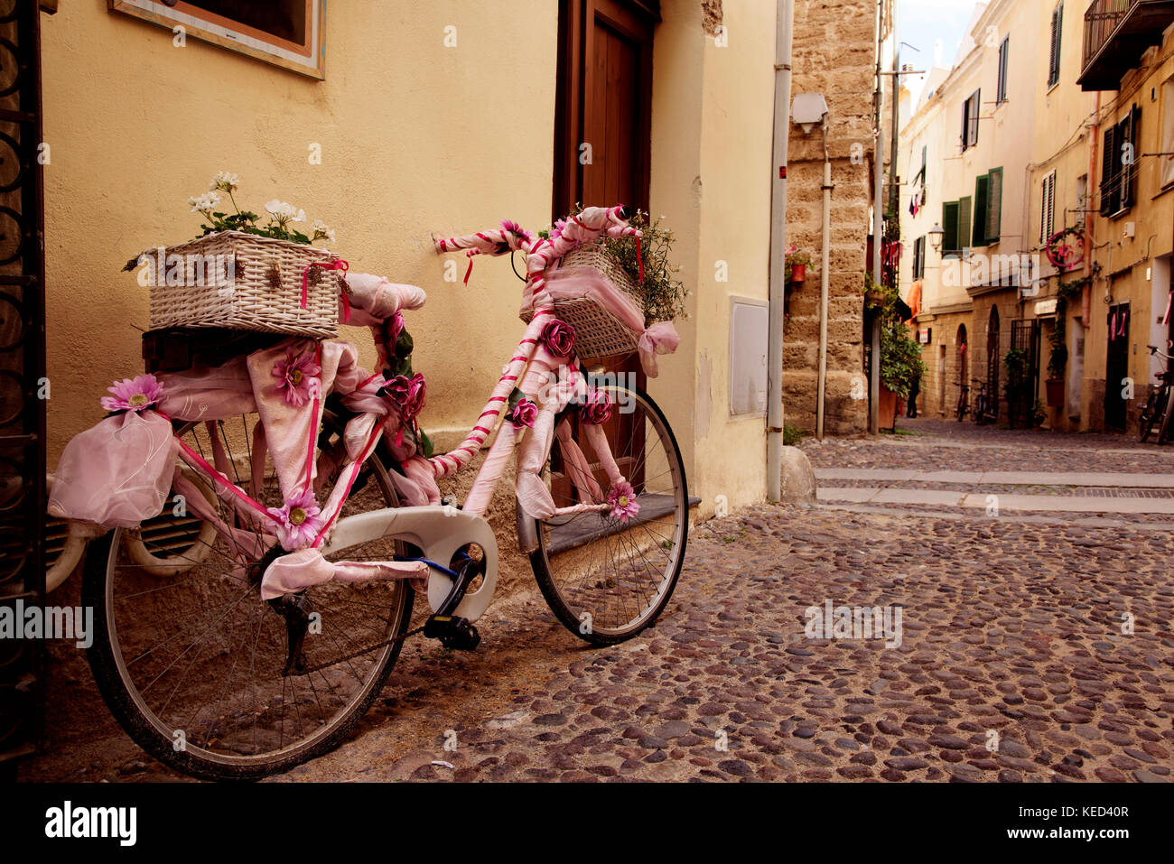 a pedestrian street in the old town of Alghero, Sardinia, Italy, with a ...
