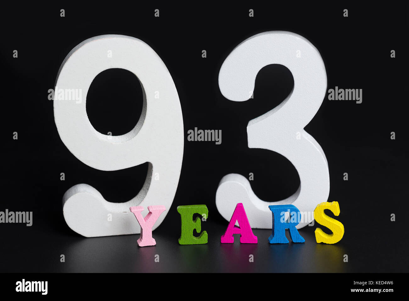 Letters and numbers ninety-three years on black isolated background ...