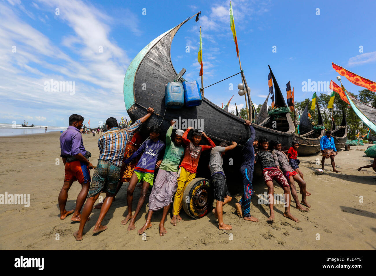 Fishermen pulling a boat to shore returning from deep sea after ...