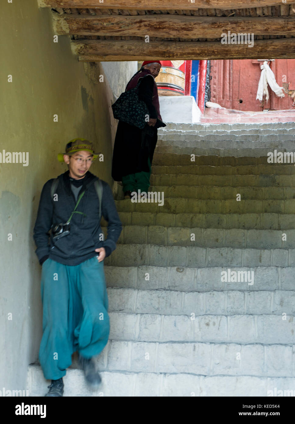 Two people passing on the stairs to a temple in Leh, Ladakh, India ...